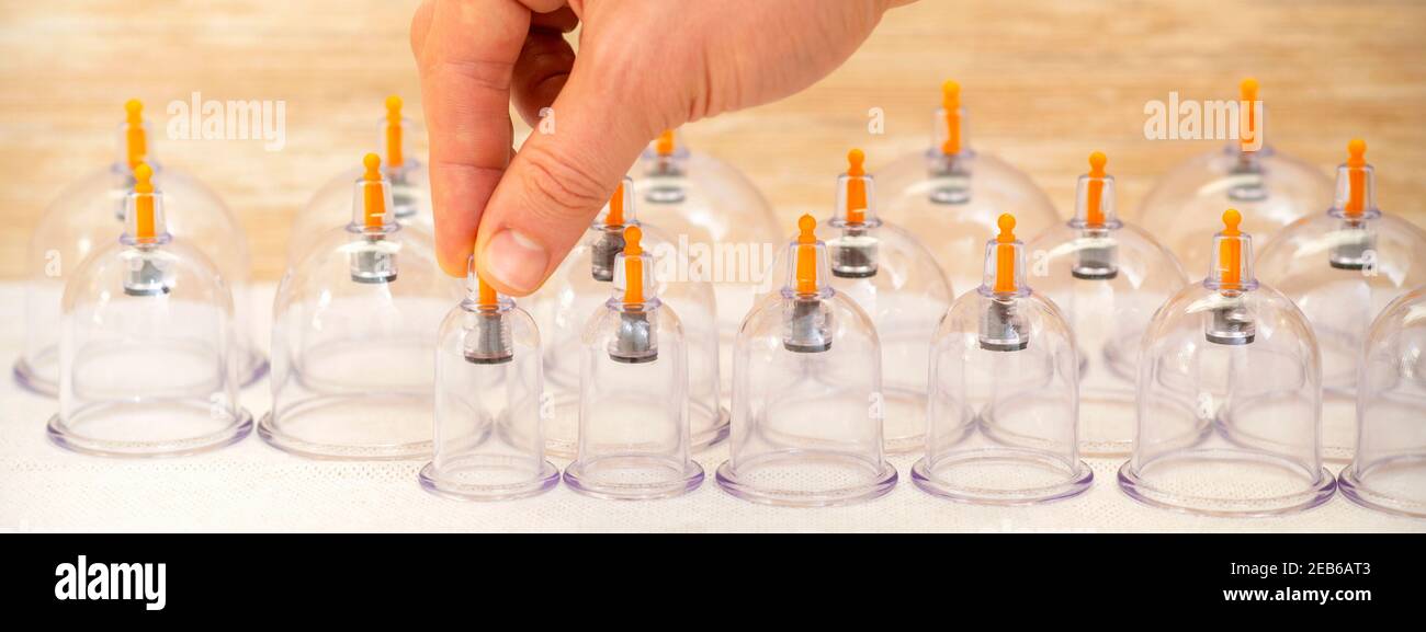 Hand of massage therapist taking vacuum cups from the table before ...