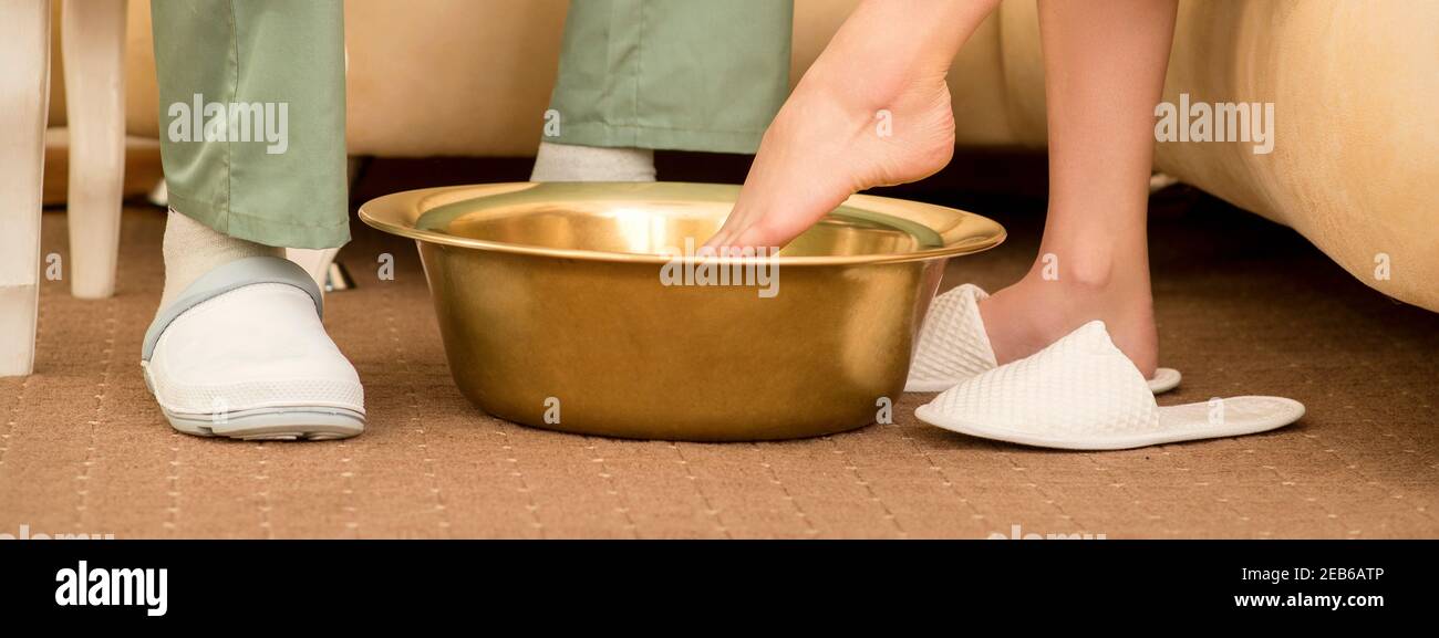 A woman is dipping feet in a bowl before washing feet therapy Stock ...