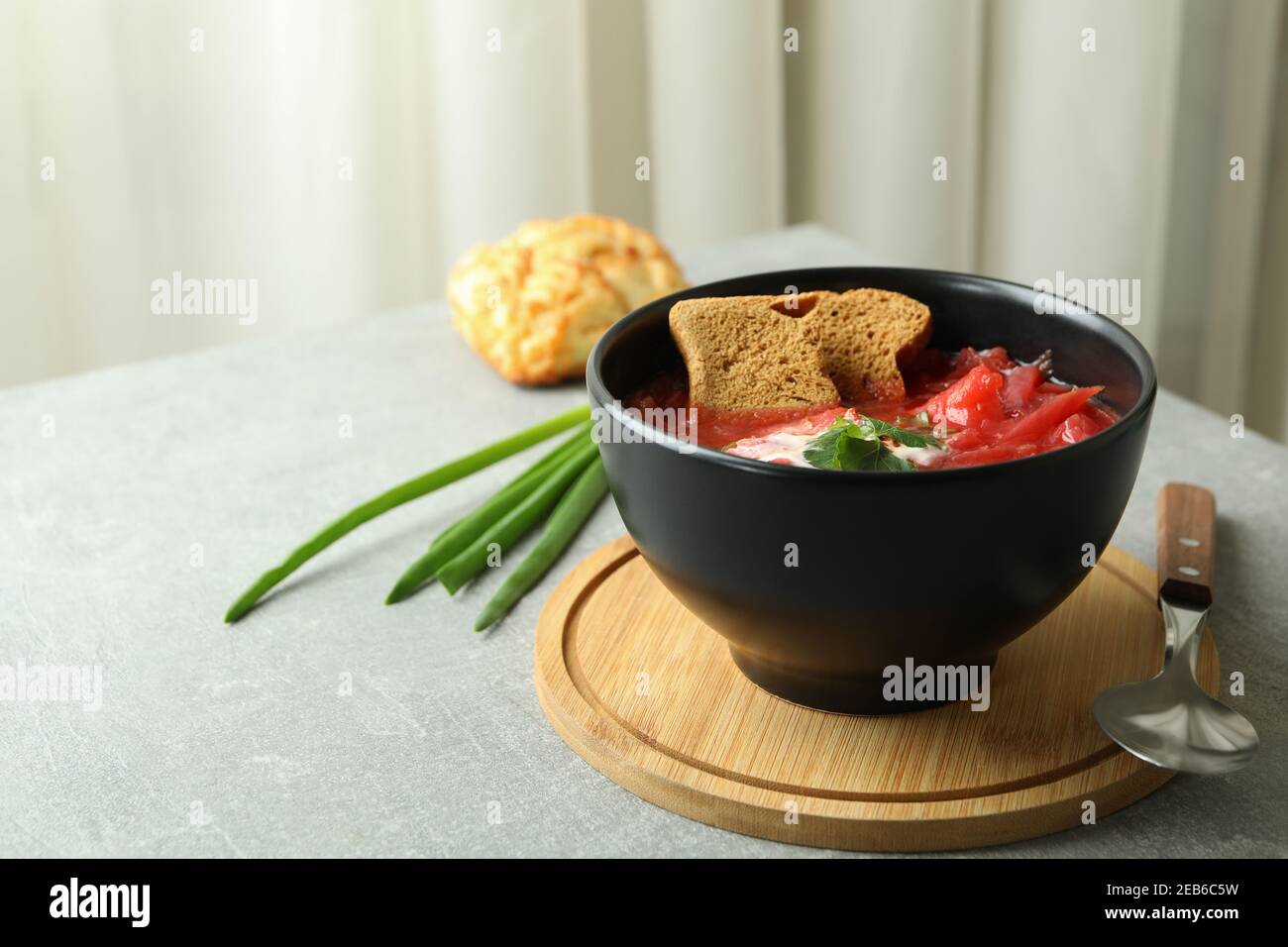 Concept of tasty eating with borscht and ingredients on gray table ...