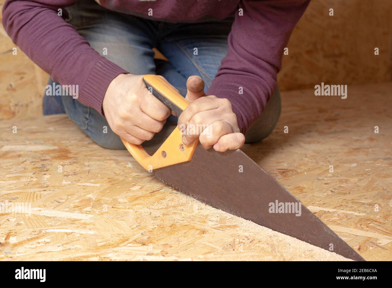 A male carpenter is sawing a chipboard. DIY construction work and home ...