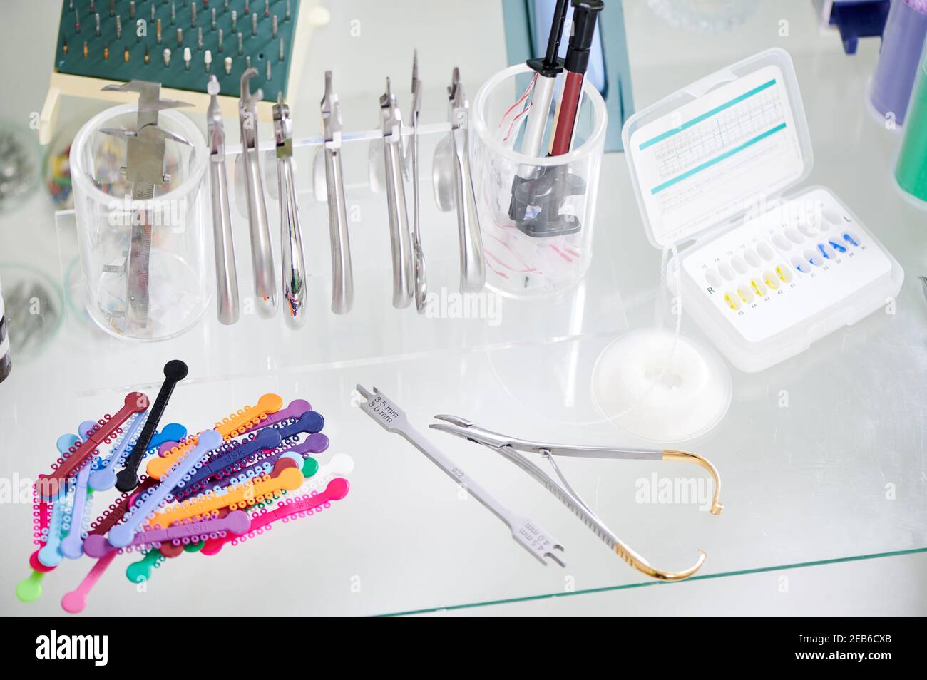 Glass table with various orthodontic instruments, bracket placement ...