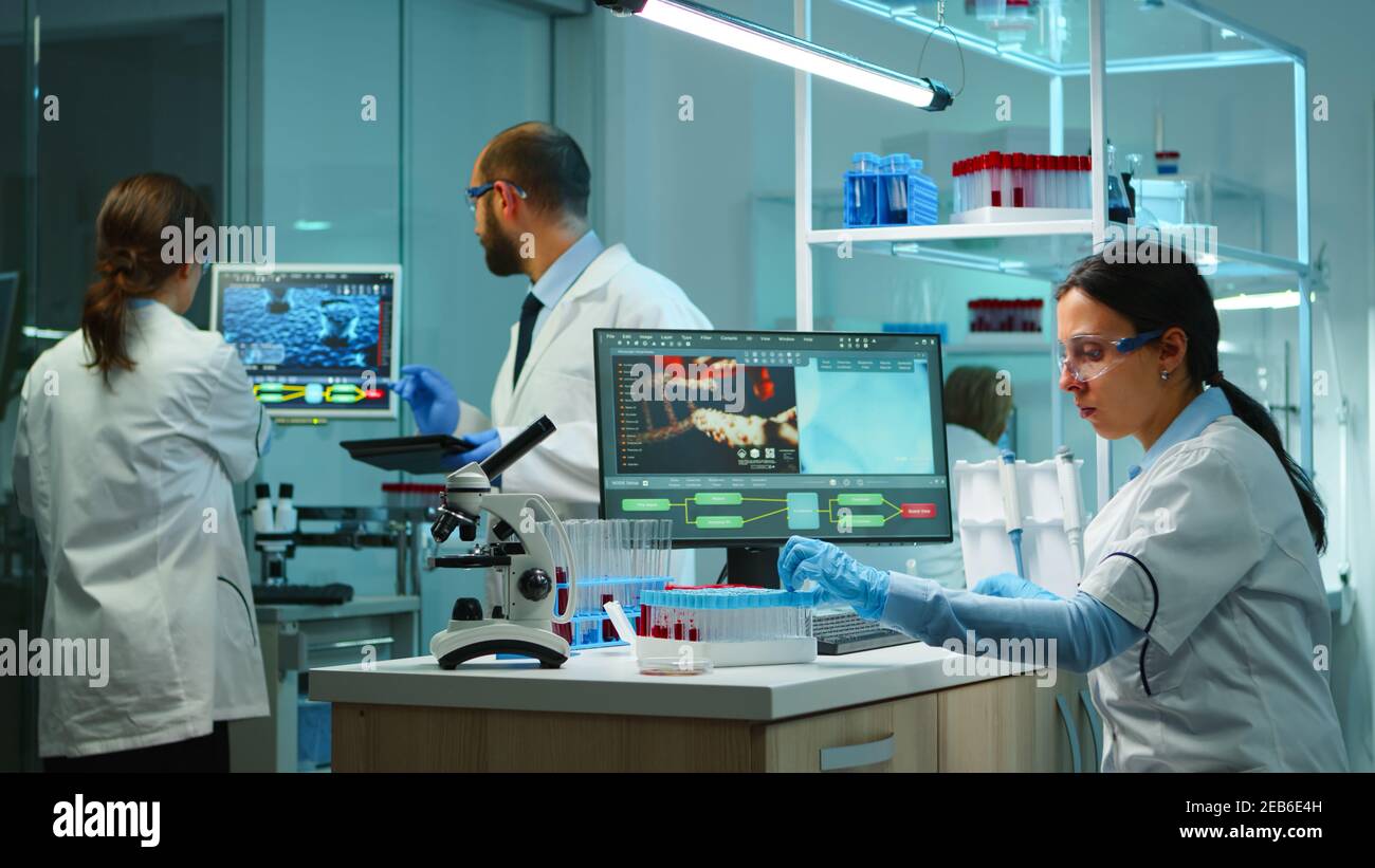 Scientist team checking virus development using high tech writing ...