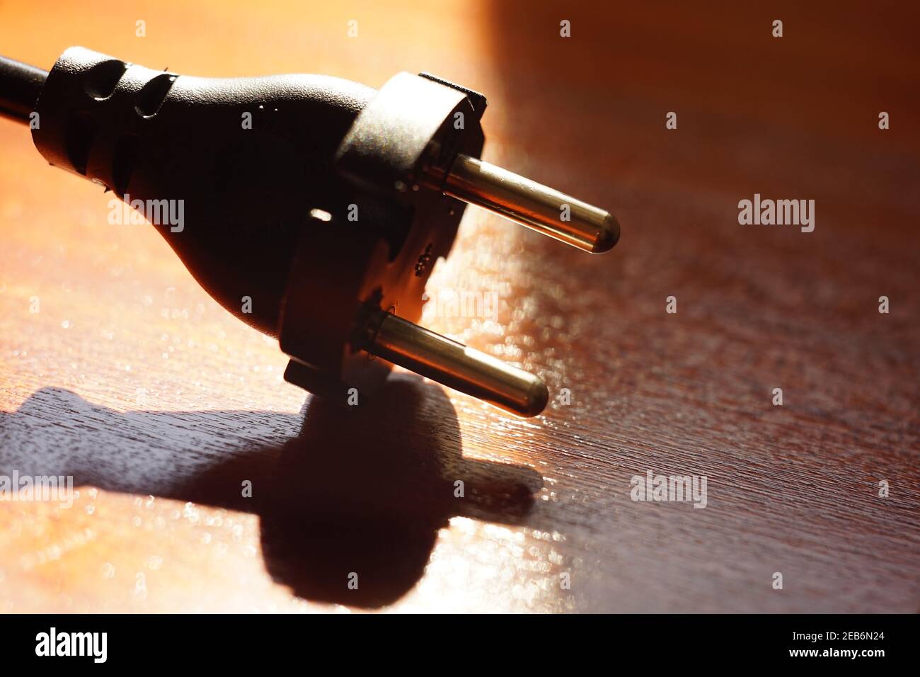 Black power plug on a brown wooden table. Side view, closeup Stock ...