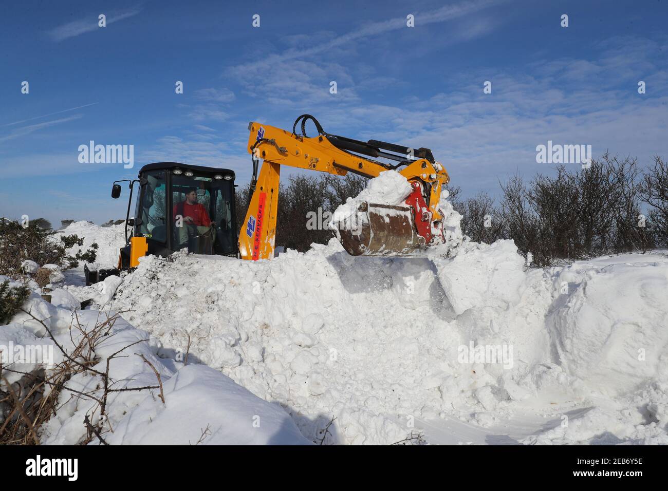 A digger gets to work removing snow on Crete Road in Folkestone, Kent ...