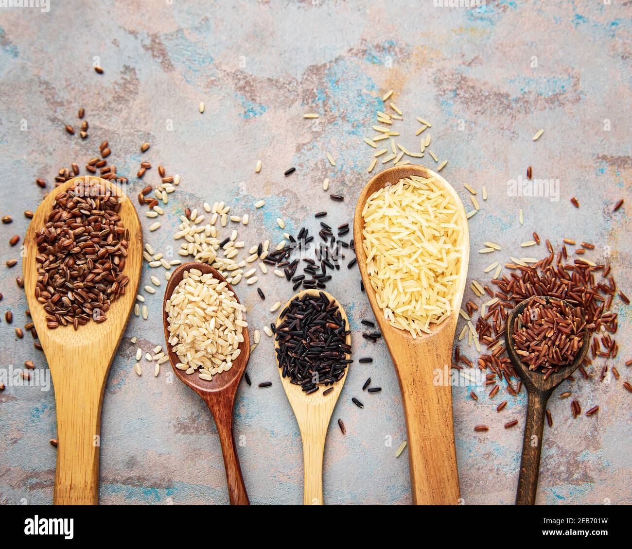 Set of various rice on concrete background: black, basmati, brown and ...