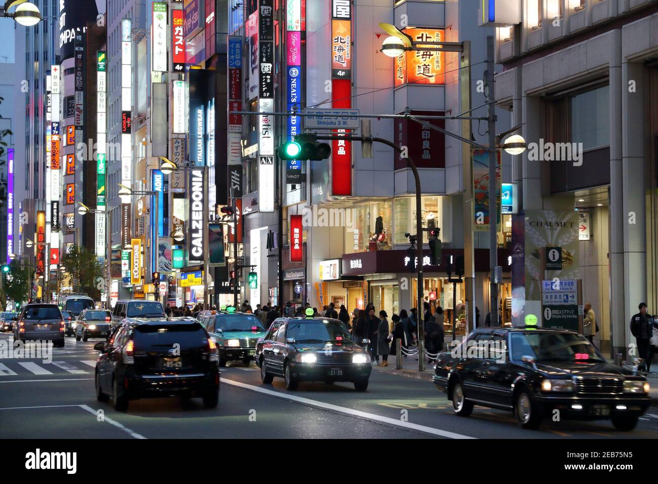 TOKYO, JAPAN - NOVEMBER 30, 2016: People walk under the neon lights of ...