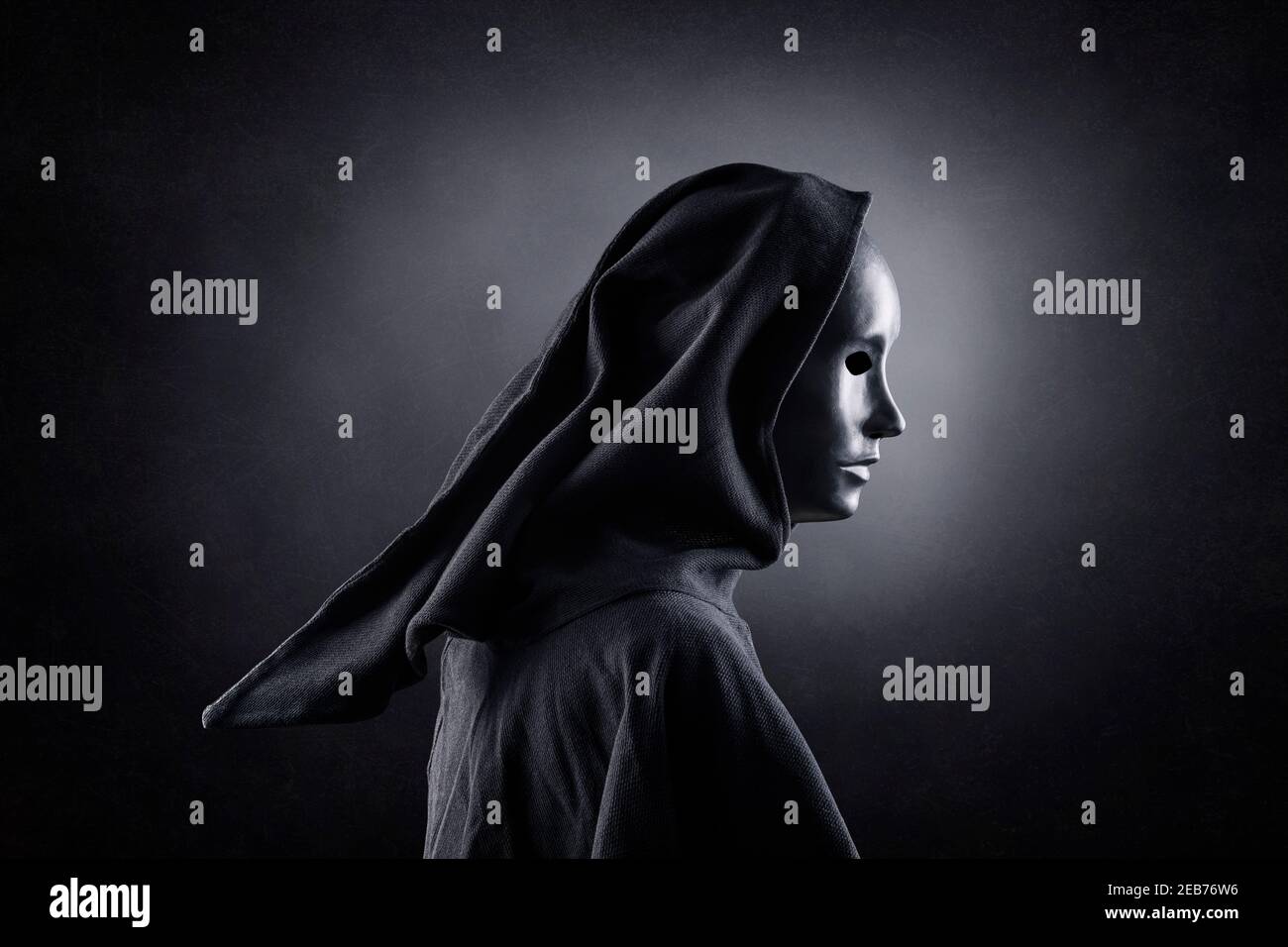 Scary figure with hooded cloak in the dark Stock Photo - Alamy