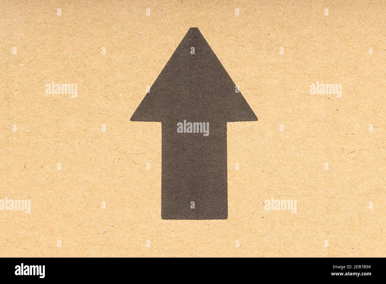Black arrow pointing up on brown cardboard background. Close up Stock ...