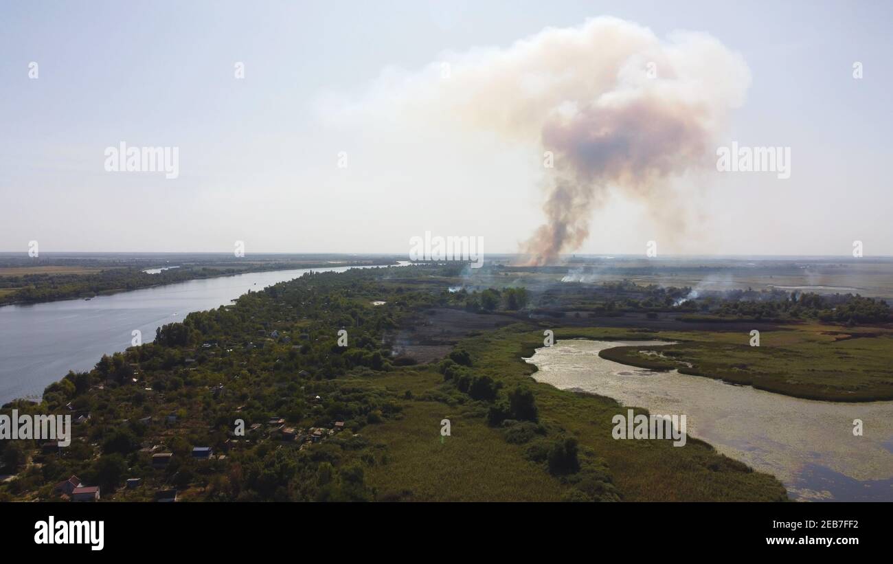 Drone fly over waving river surrounded by local village with various ...