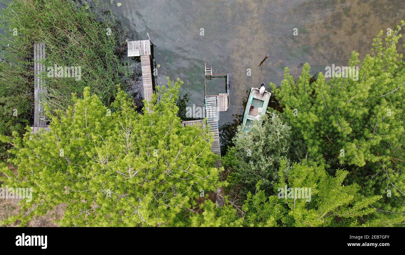 Drone fly over waving river of blue color surrounded by local village ...