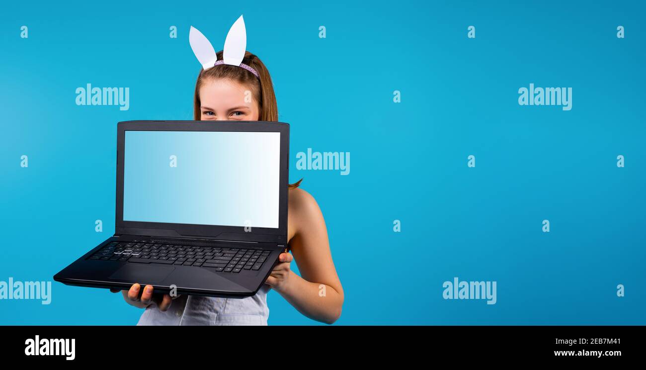 Banner,long format. Girl with bunny ears hiding her face behind laptop ...