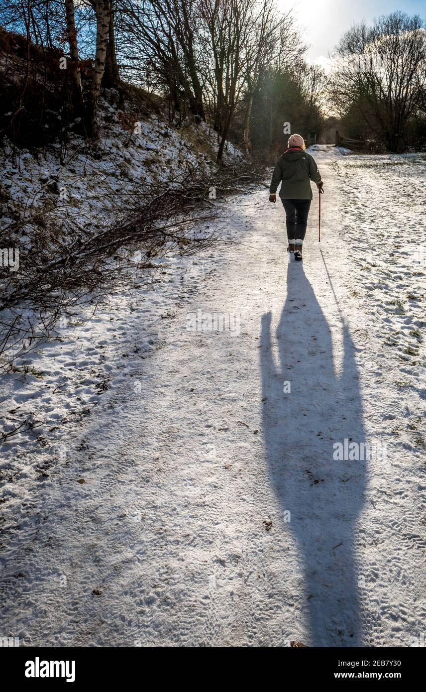 female walking along a icy track covered with snow Stock Photo - Alamy