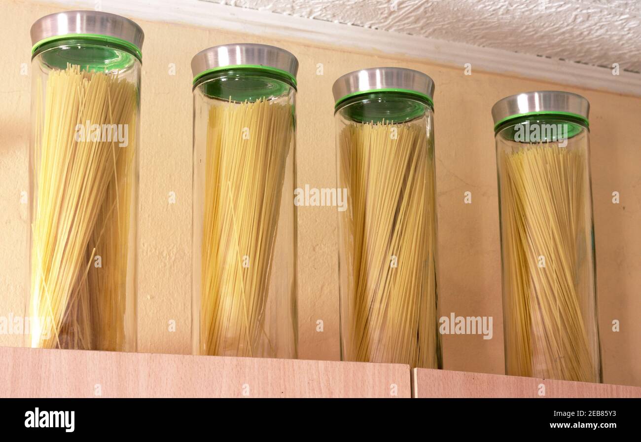 straight long thin pasta in four transparent elongated jars, closed ...