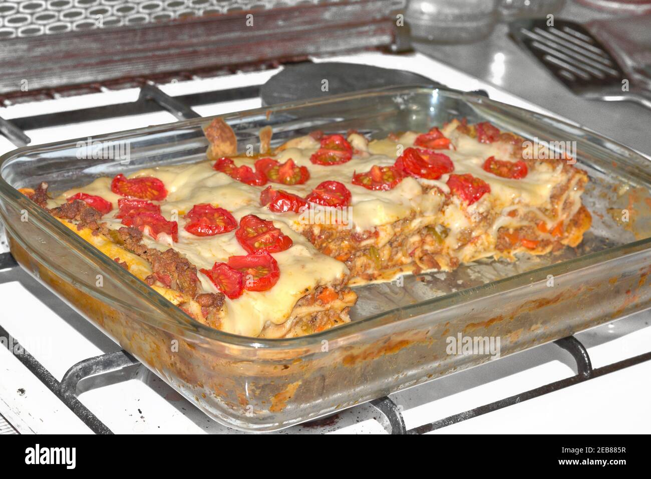 homemade lasagna with cherry tomatoes in glass baking dish, on grate of ...