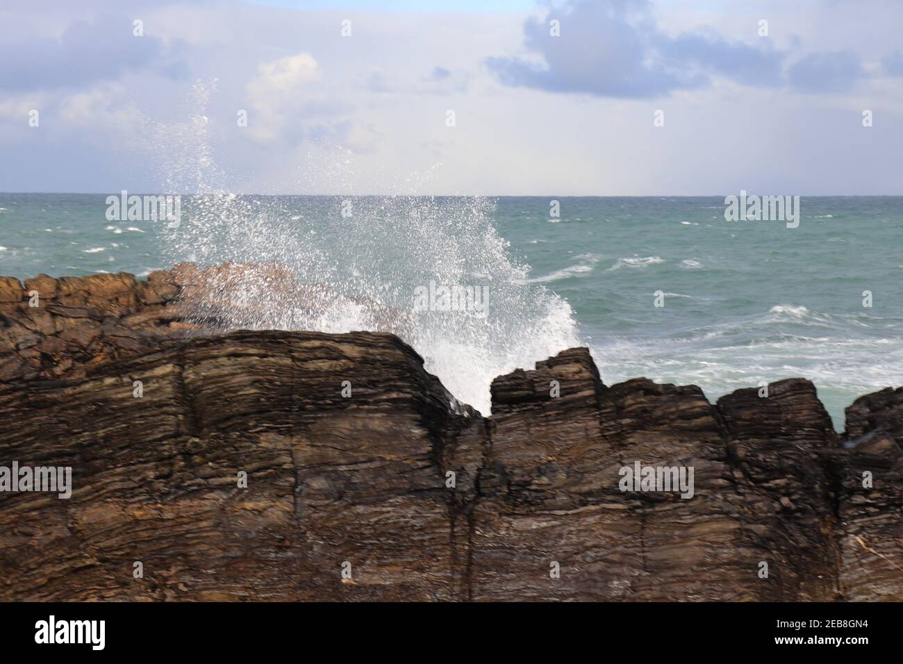 Wave splashing on rocks Stock Photo - Alamy