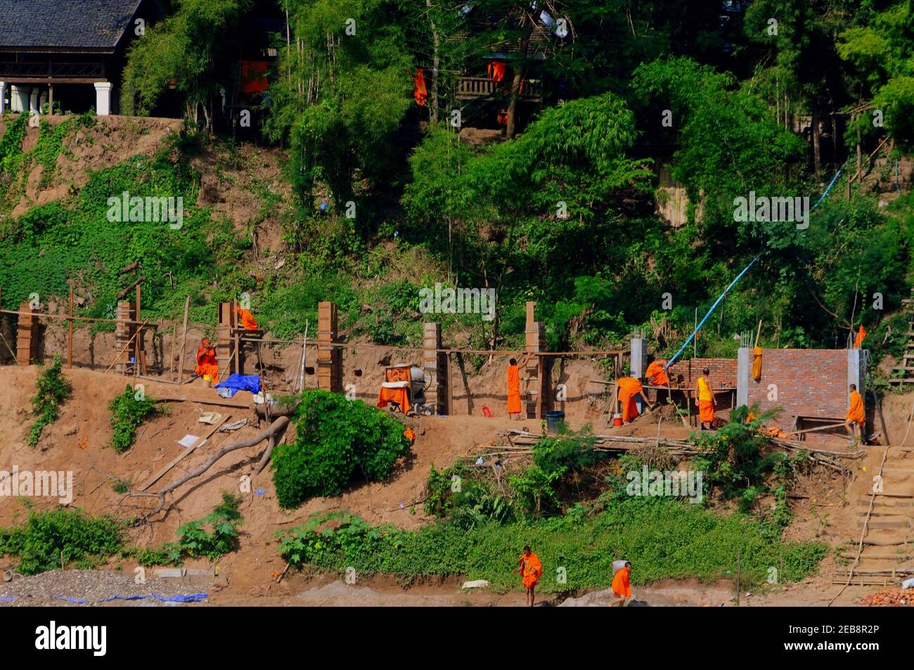 Buddhist monks work on the outside facilities of the monastery, Luang ...