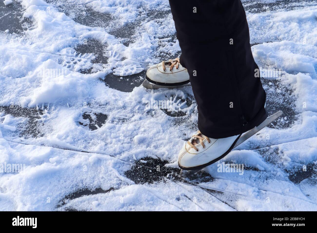 Close up on womans feet wearing ice skating boots and standing on ice ...