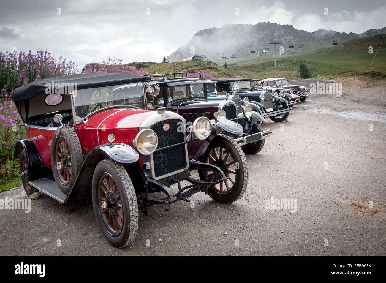 Line of vintage cars parked in the french alps with mountains in ...