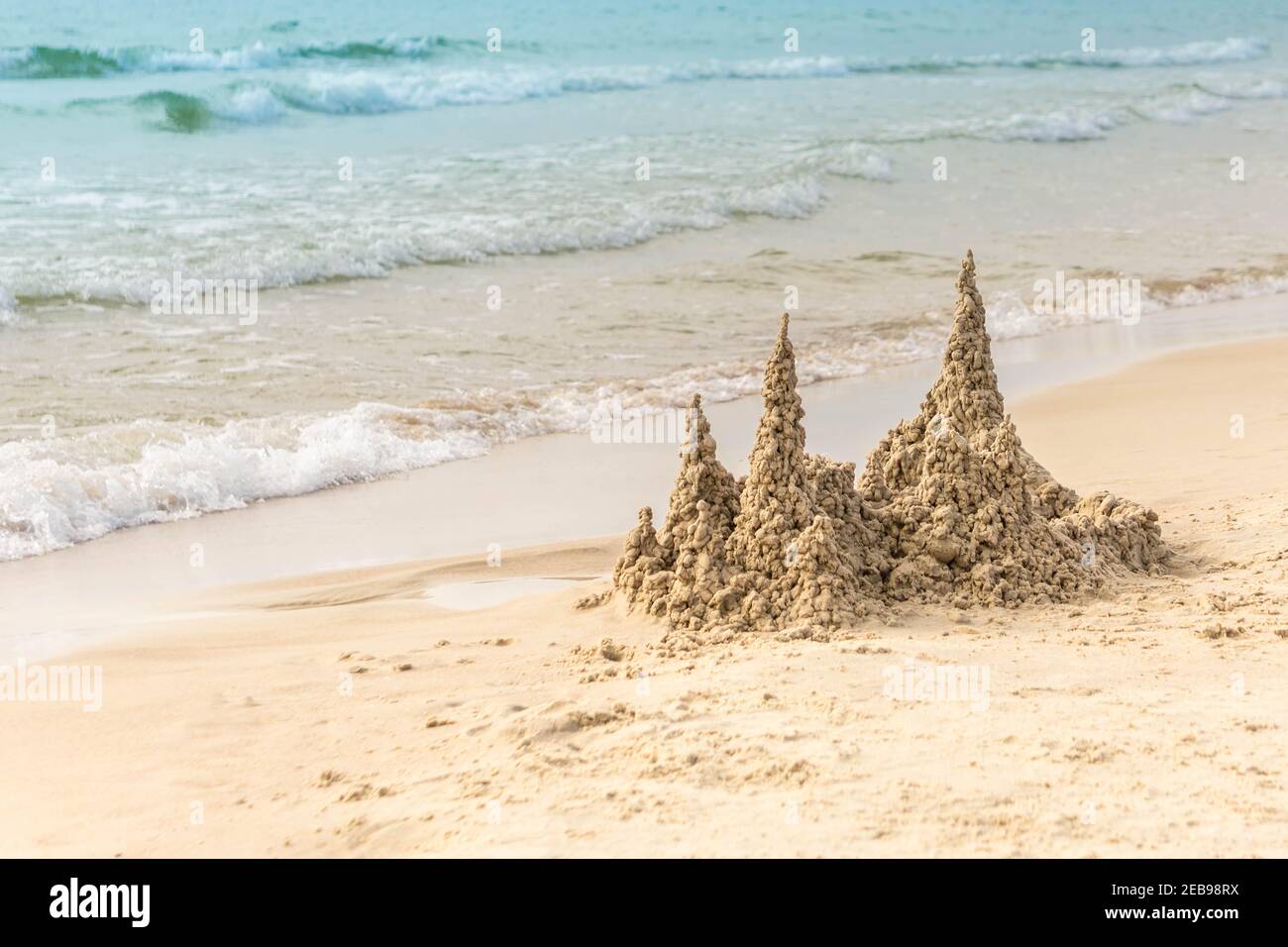 Sand house or sandcastle with towers built of wet sand on seashore of ...