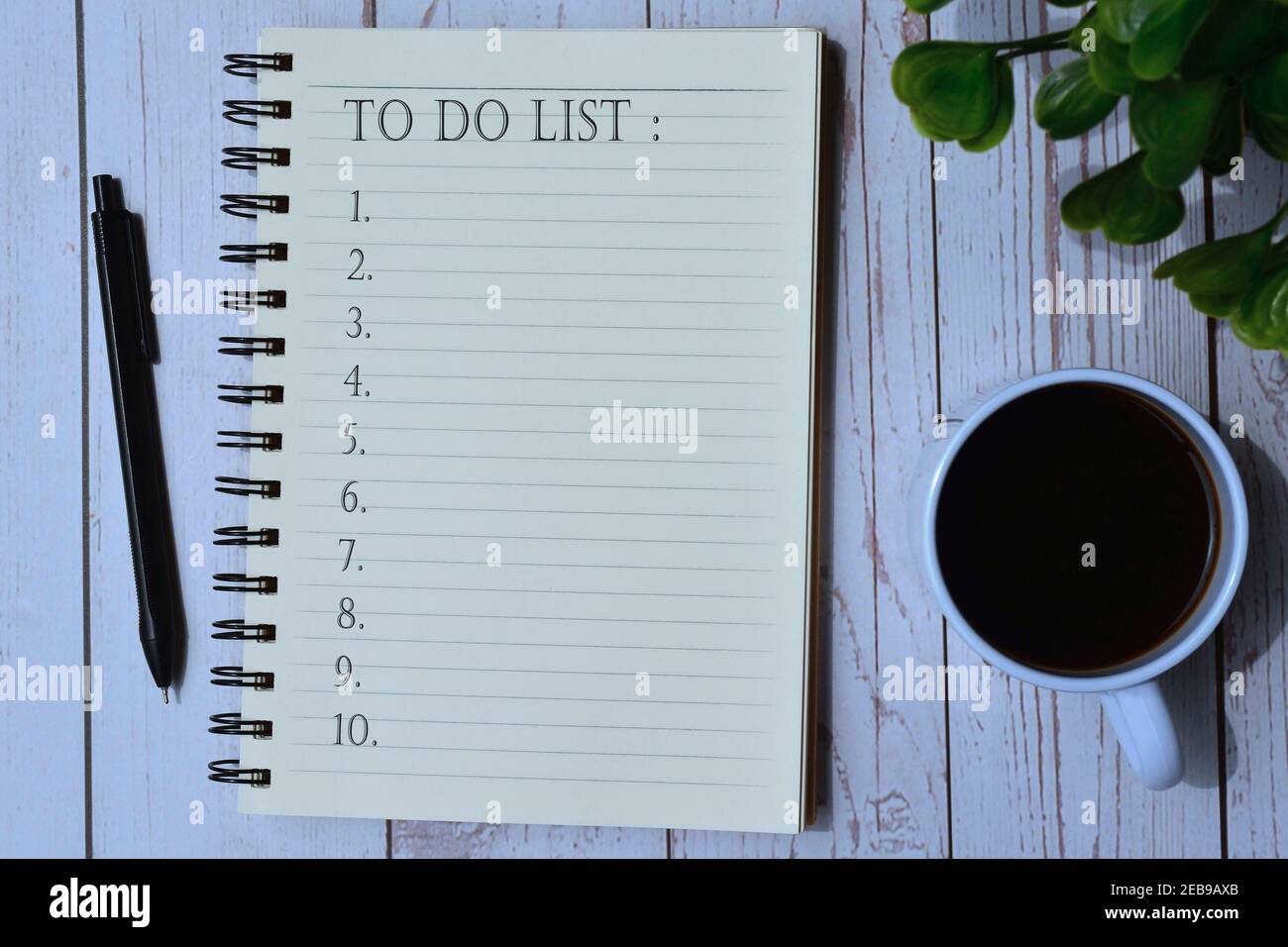 To do list on notepad with cup of coffee, pen and green leaf background ...