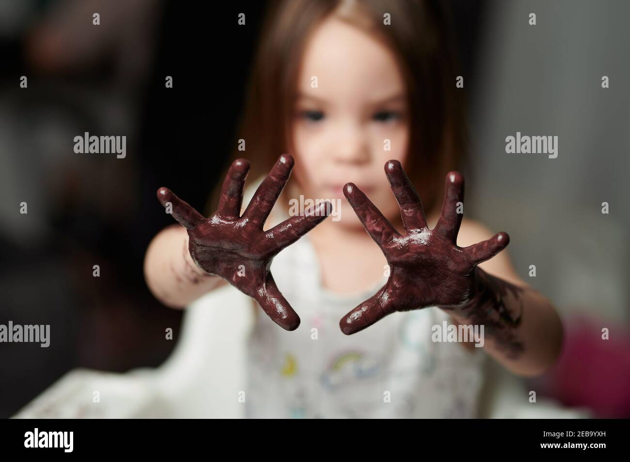 Girl child palm hands painted in dark brown color. Play messy with ...