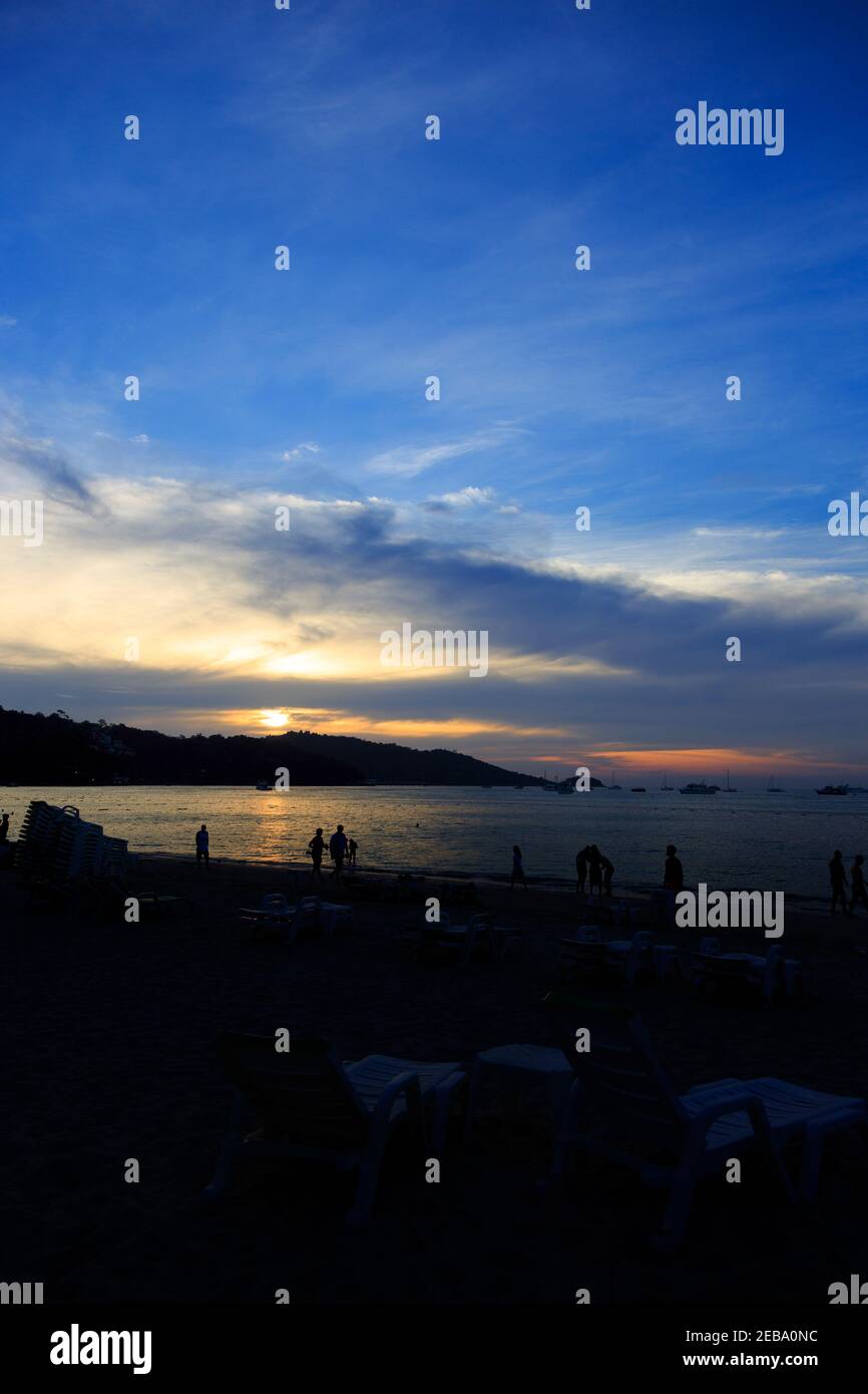 Silhouettes of group of people during the sunset in Seaside beach ...