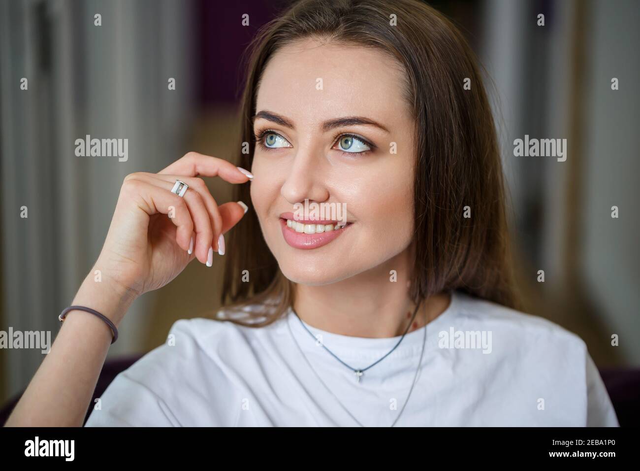A young woman is sitting on the couch and working on a laptop remotely ...
