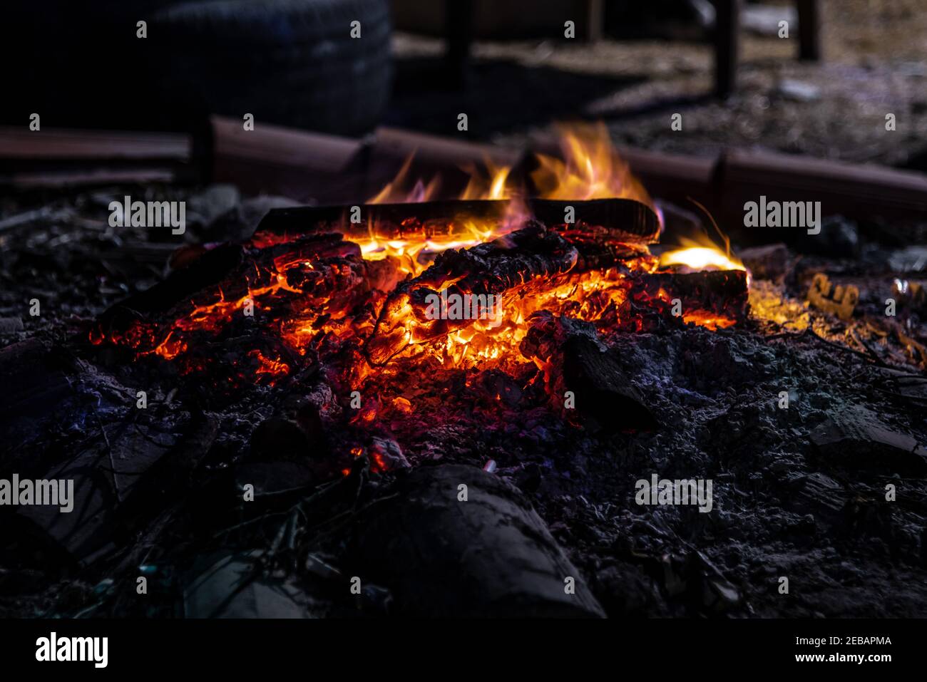 Camp fire with small logs of wood burning outdoors in dark Stock Photo ...