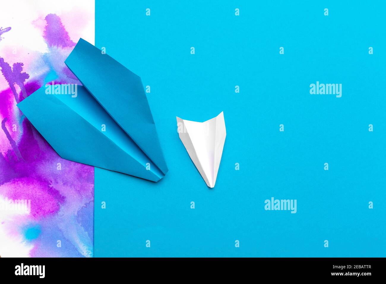 white paper airplane on a color block paper background Stock Photo - Alamy
