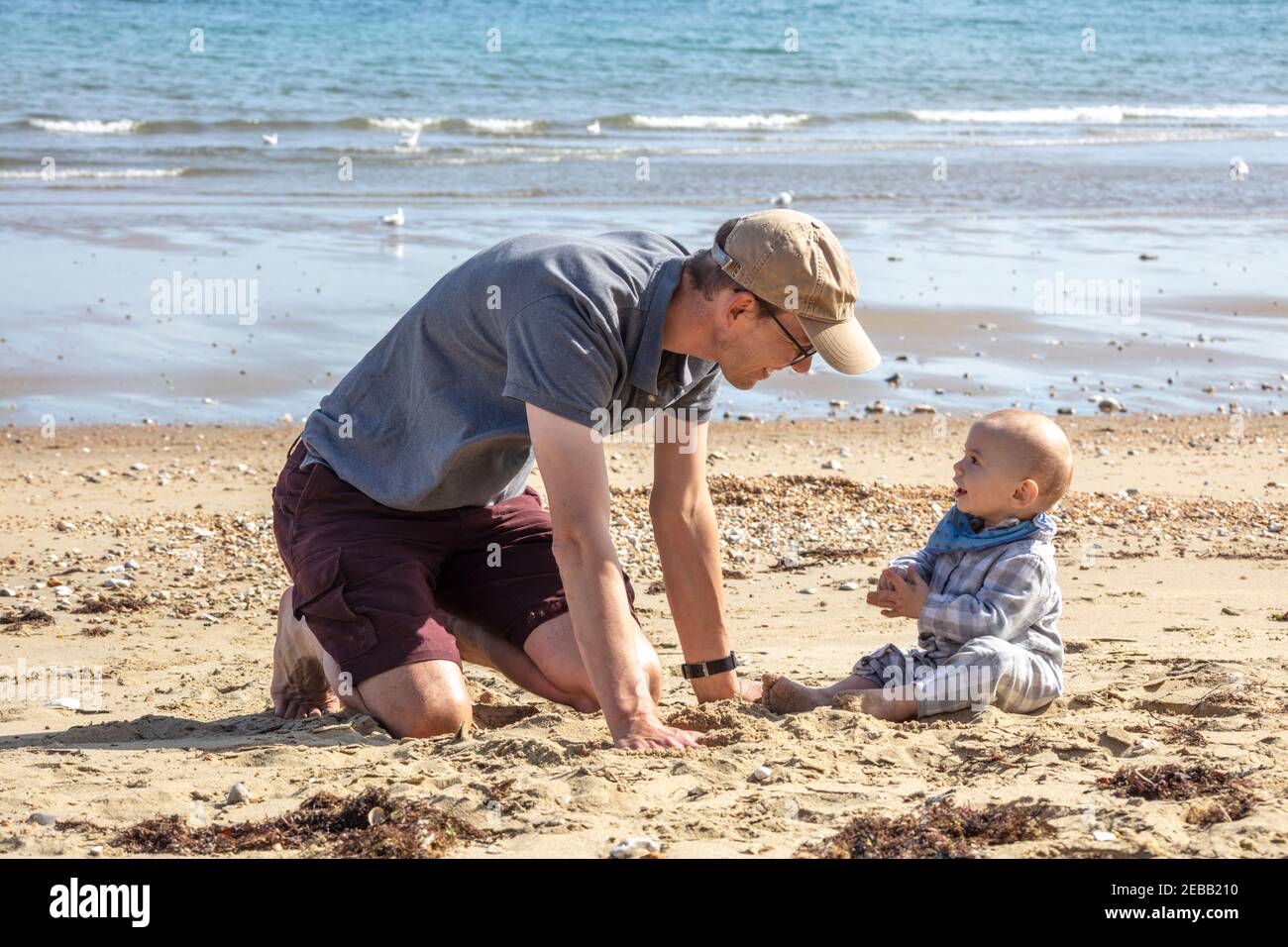 Dad and son in the beach. Baby boy looking at his father in a beach in ...