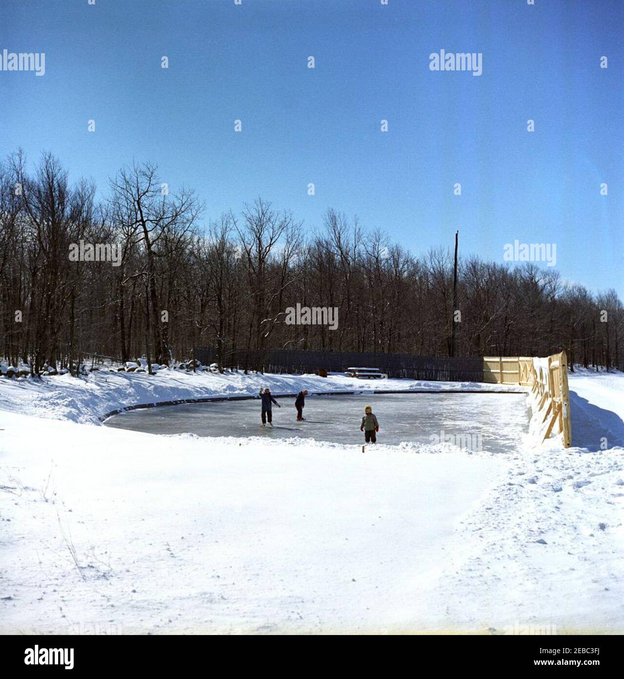 Camp David in the snow, views. Three unidentified children skate on a ...