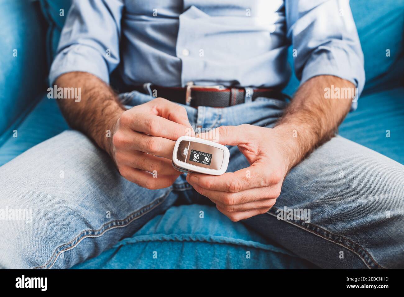 Man monitors heart rate and oxygen levels with a handheld pulse ...
