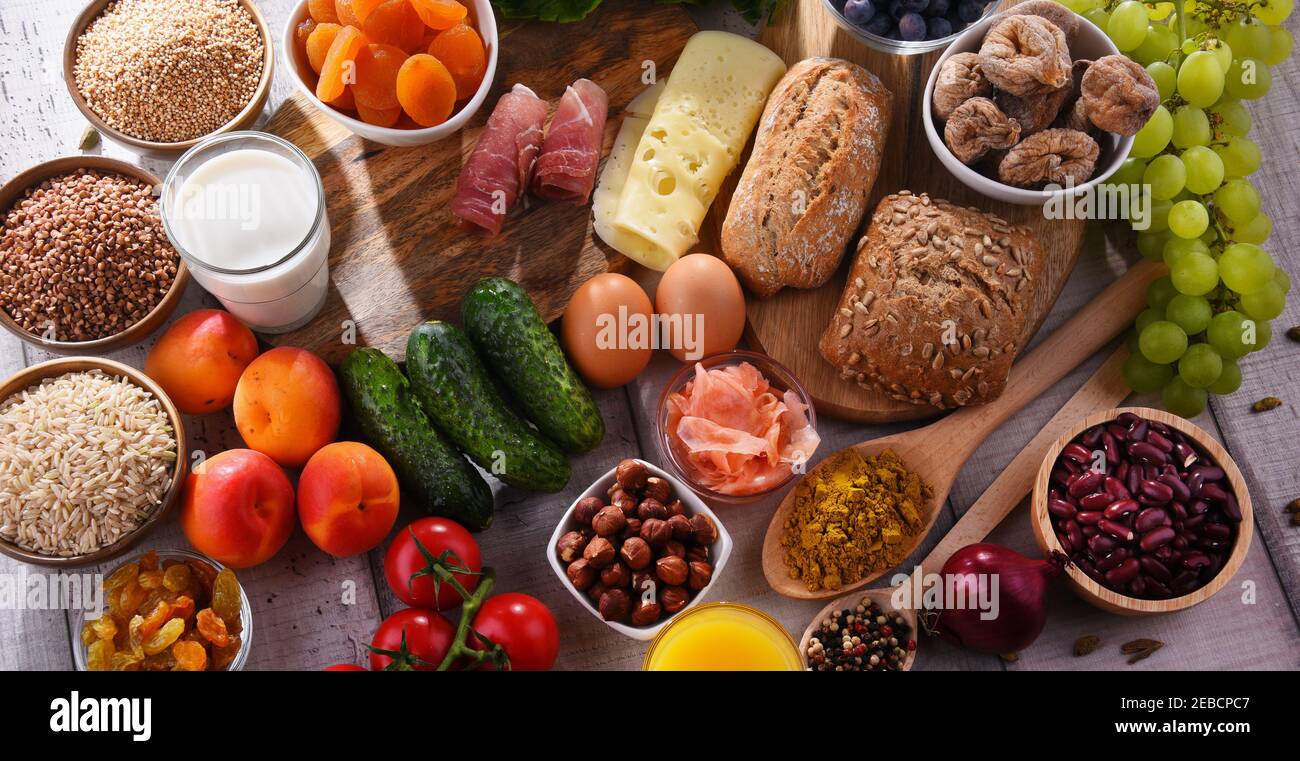 Composition with assorted organic food products on wooden kitchen table ...