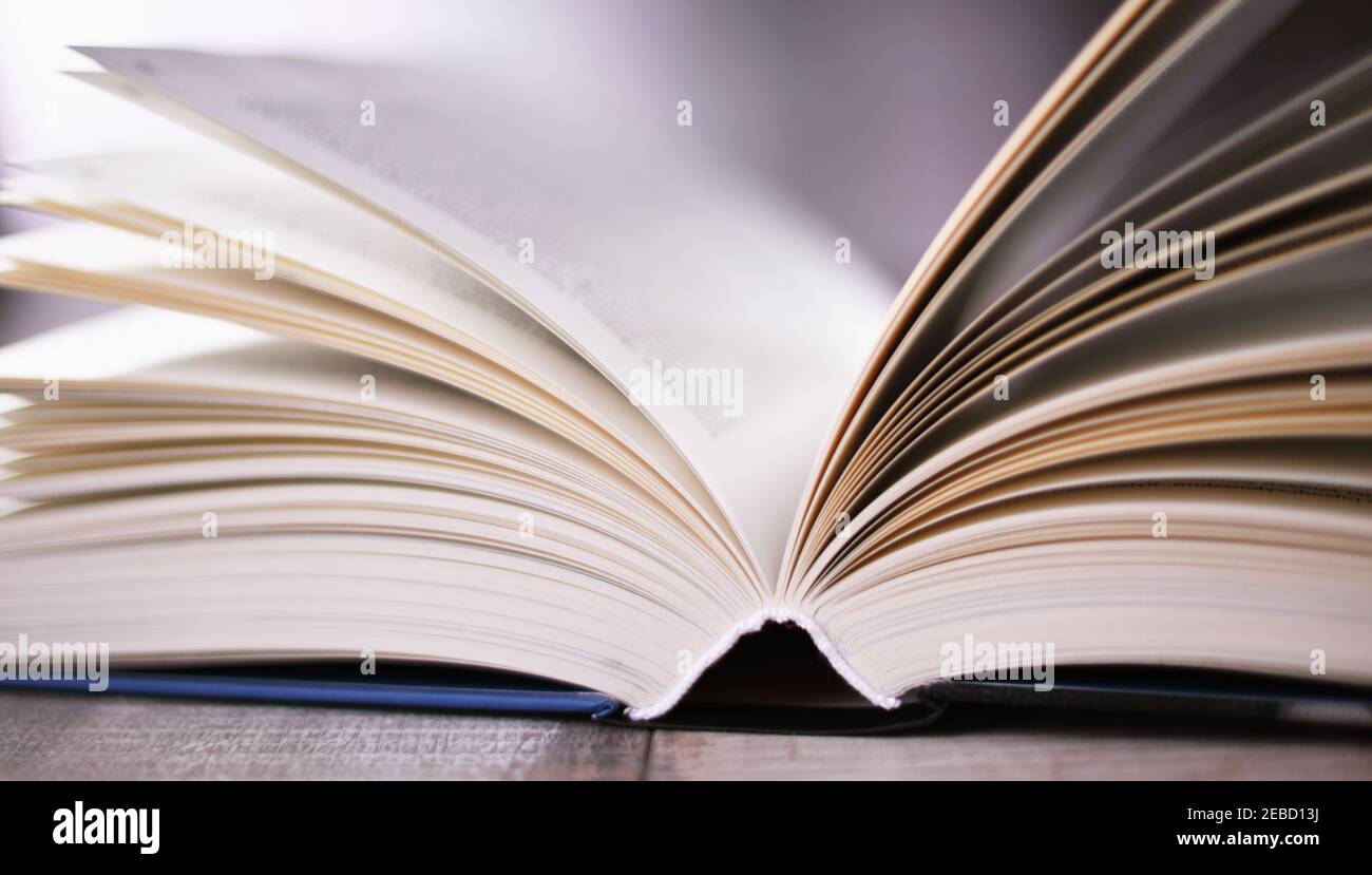 Composition with open book on the table Stock Photo - Alamy