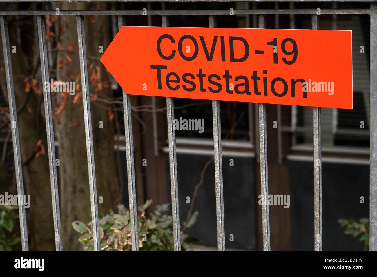 Test station Covid-19 signpost in German language in orange color and ...