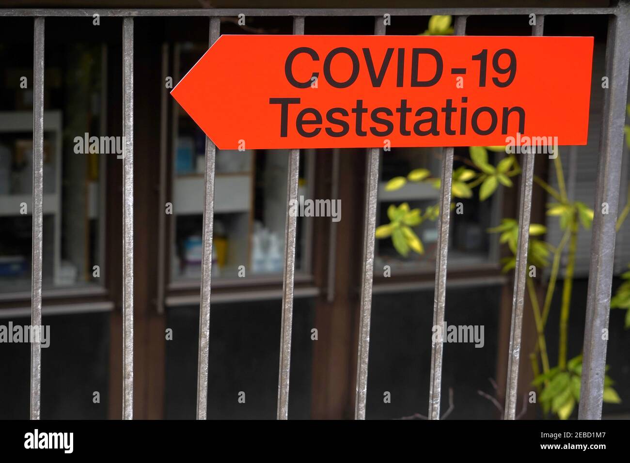 Test station Covid-19 signpost in German in orange color and in the ...