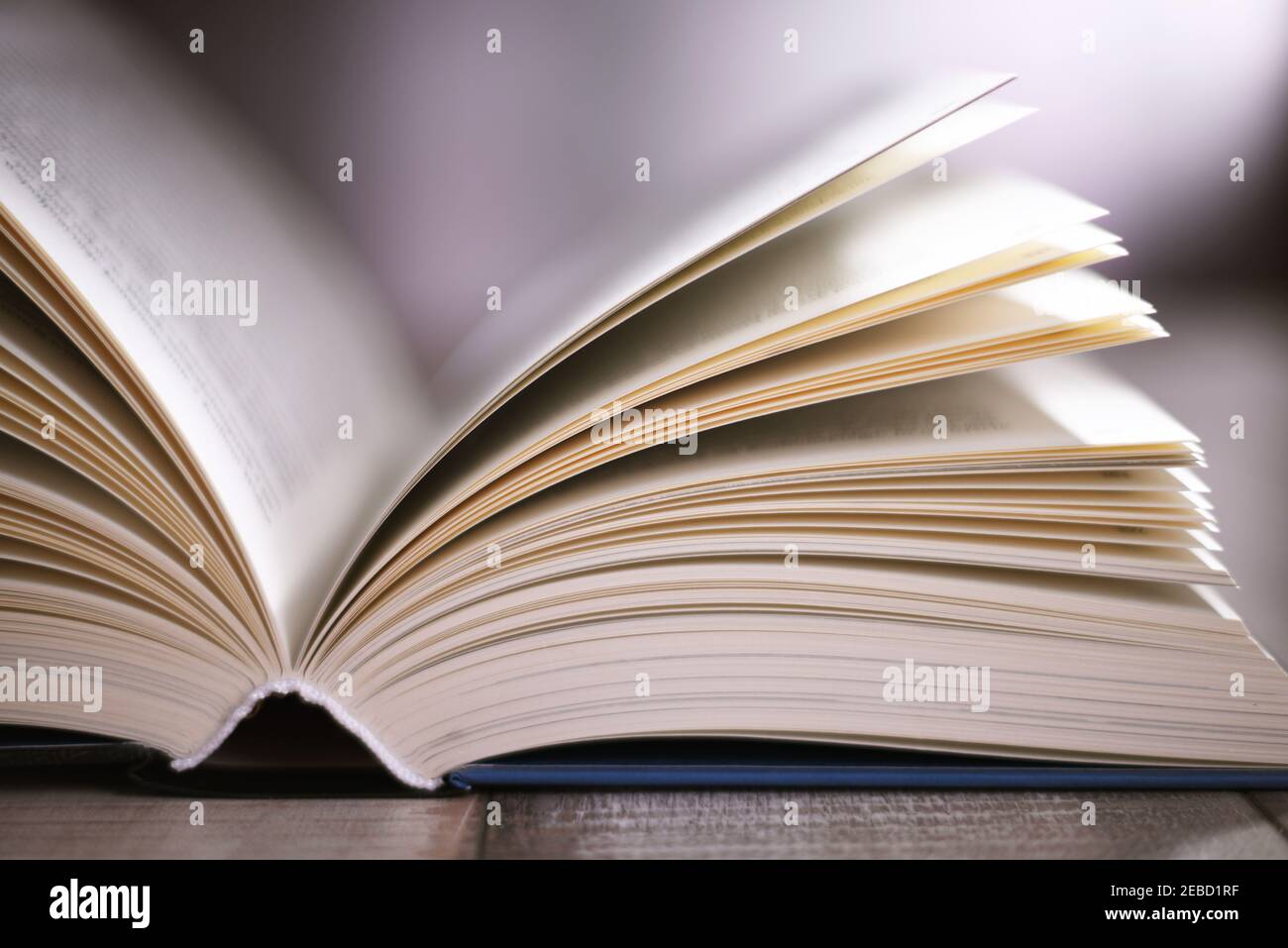Composition with open book on the table Stock Photo - Alamy