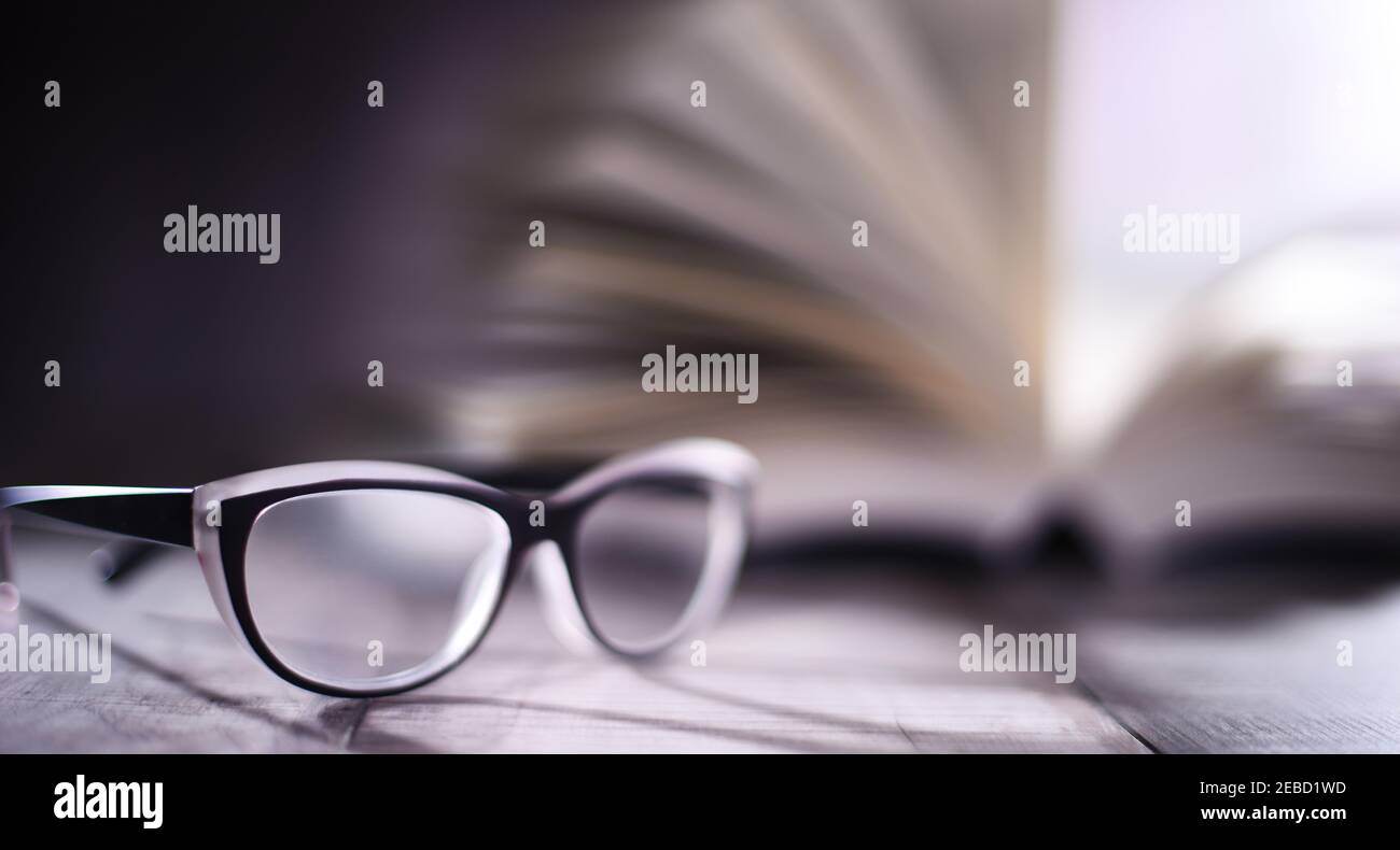 Composition with glasses and open book on the table Stock Photo - Alamy