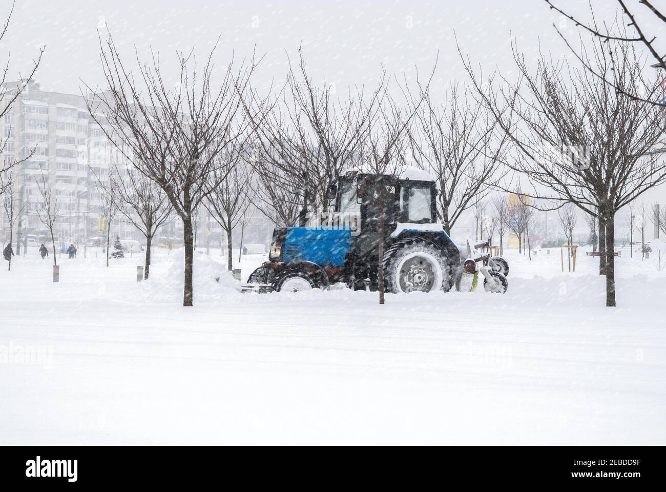 Snow-covered street. Snowplow removing snow from city road. Heavy ...
