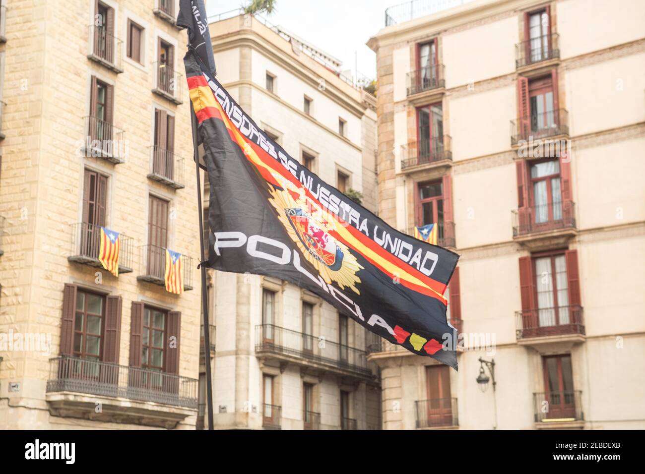 Flag of the National Police Corps of Spain waving in front of buildings ...