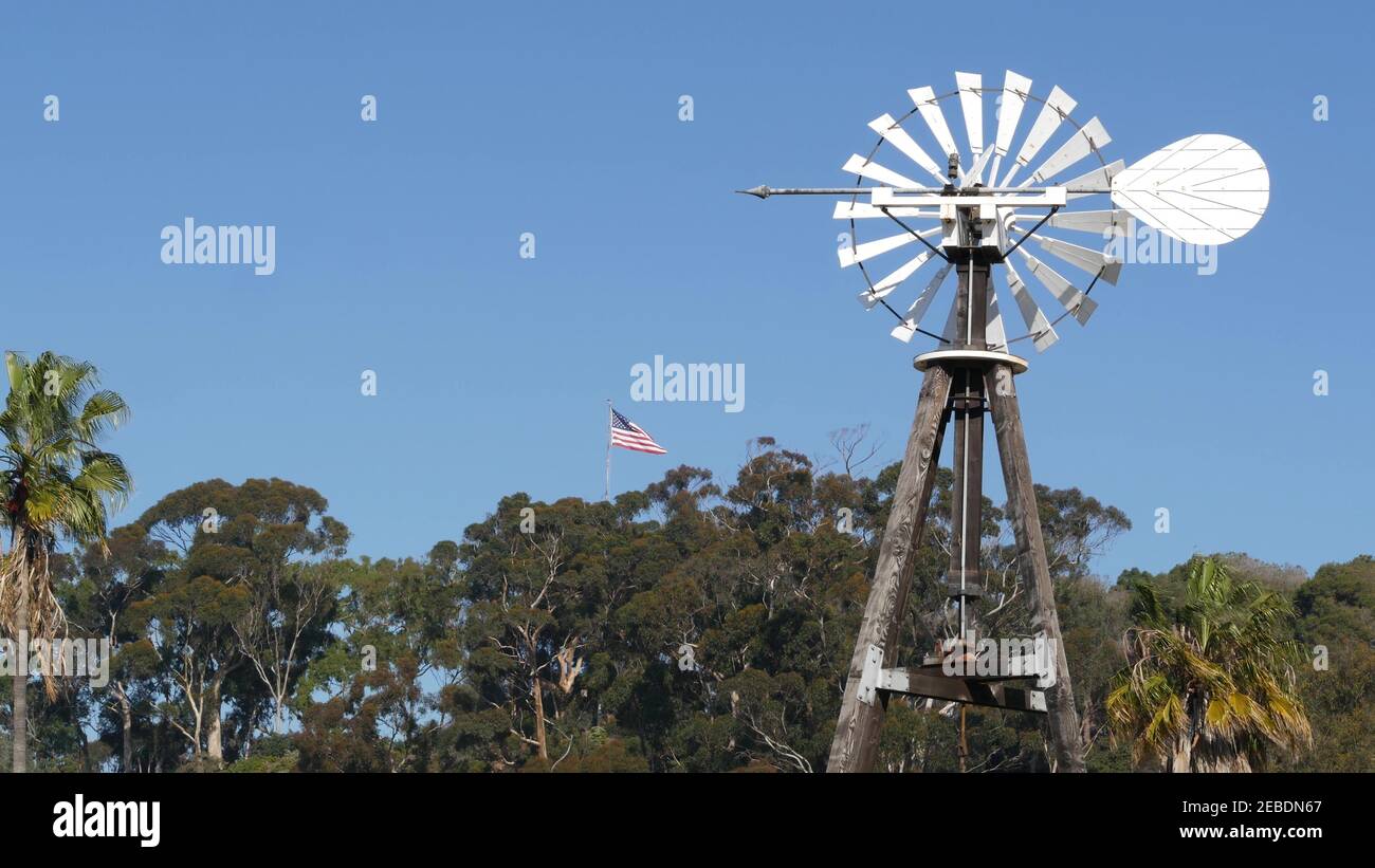 Classic retro windmill, bladed rotor and USA flag against blue sky ...