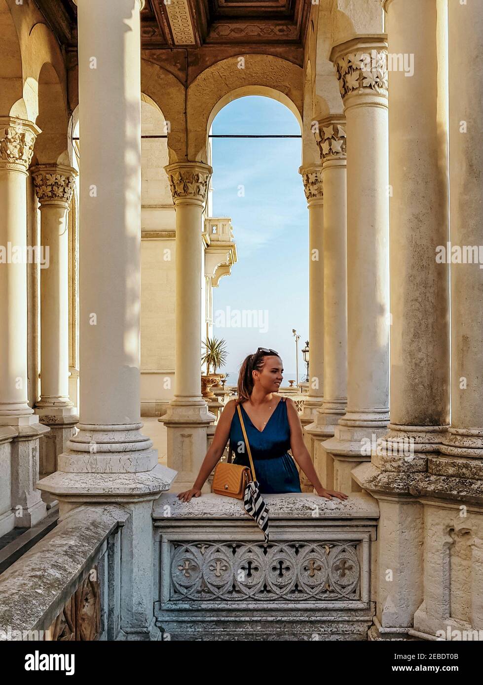 Female tourist posing by the columns of Miramare castle patio, Trieste ...