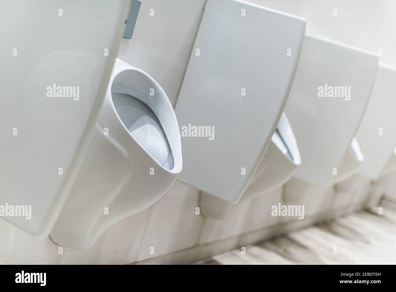 Sensor-operated urinals with privacy walls in a public men's toilet ...