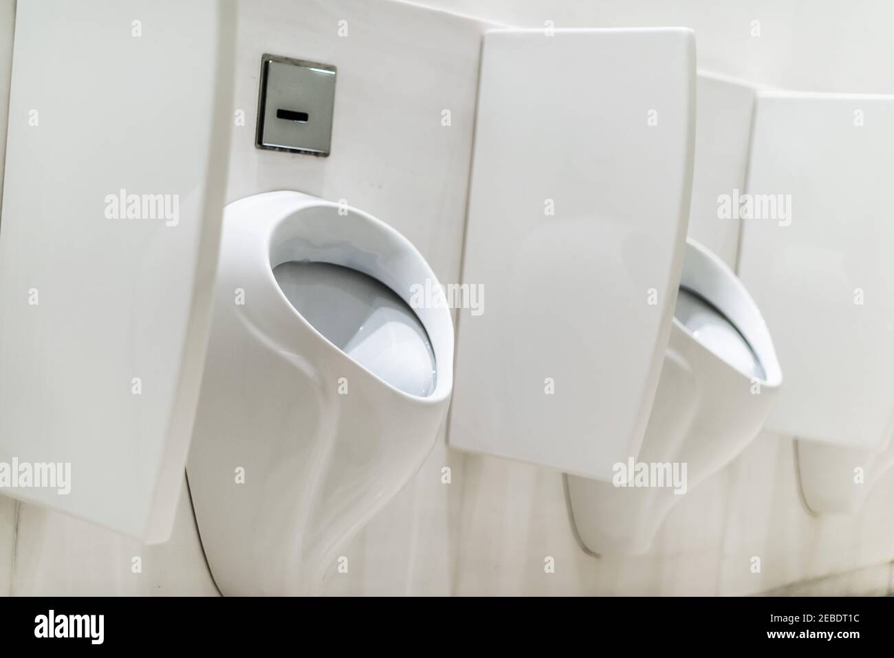 Sensor-operated urinals with privacy walls in a public men's toilet ...