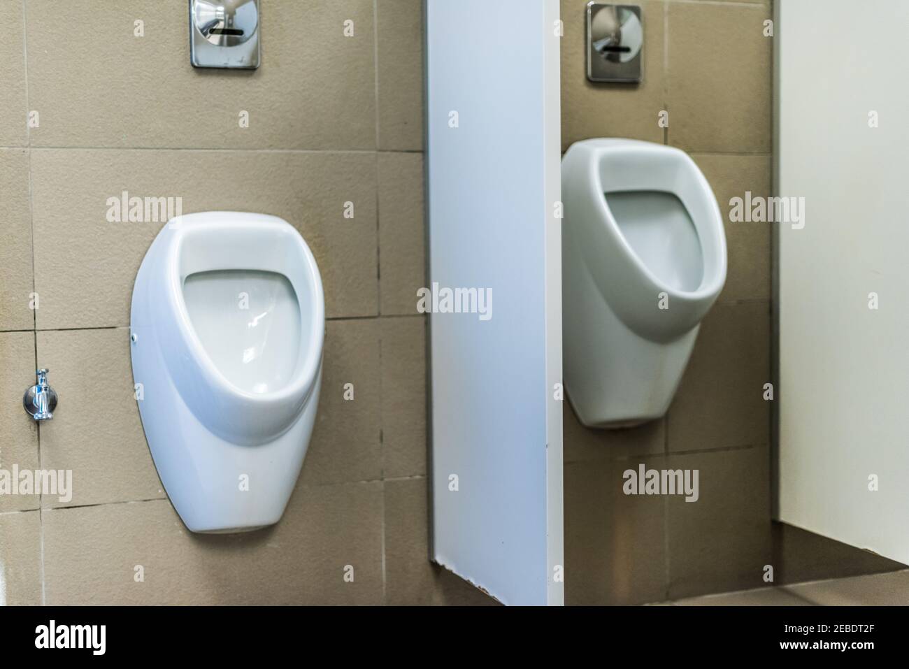 Sensor-operated urinals with privacy walls in a public men's toilet ...