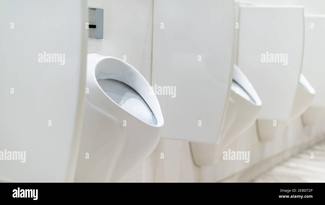 Sensor-operated urinals with privacy walls in a public men's toilet ...