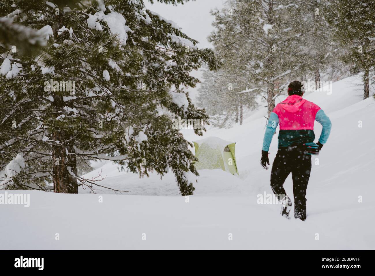 A man in bright jacket walks through deep snow out his tent Stock Photo ...