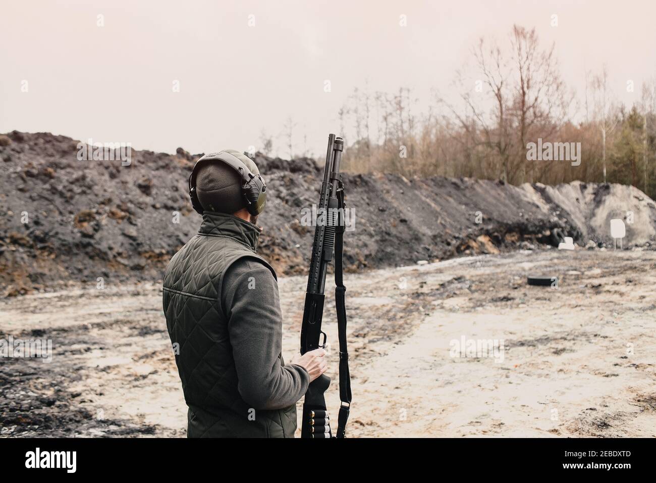 A guy shoots from a hunting rifle on the shooting range in the desert ...
