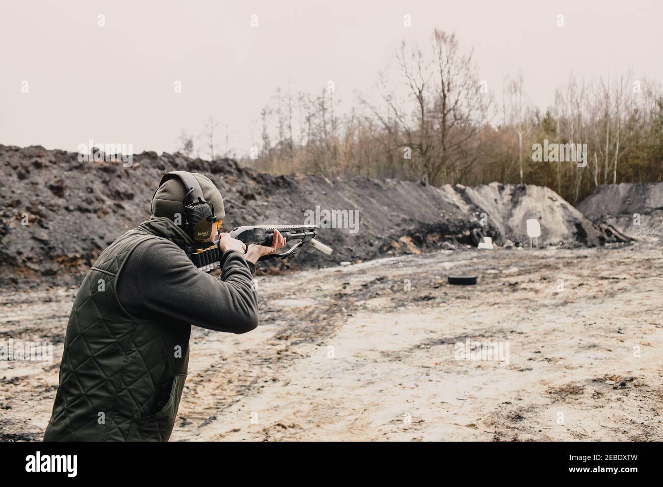 A guy shoots from a hunting rifle on the shooting range in the desert ...