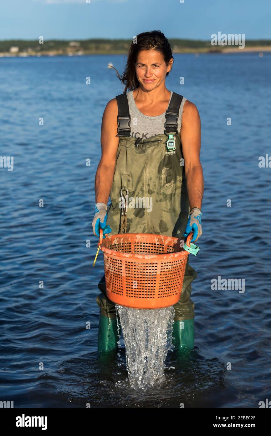 Portrait of female oyster picker in waders smiling at camera Stock ...